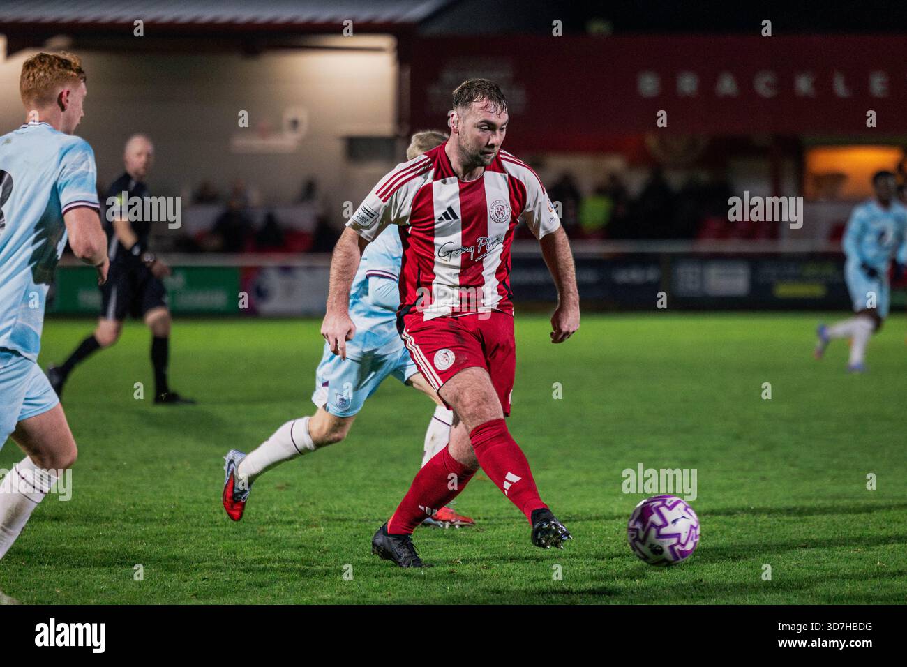 Brackley, UK. 25th Nov, 2025. Connor Hall (27 Brackley Town) passes the ...