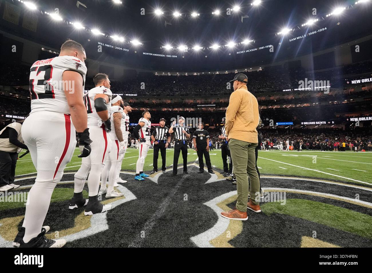 A referee performs the coin toss before an NFL football game between ...