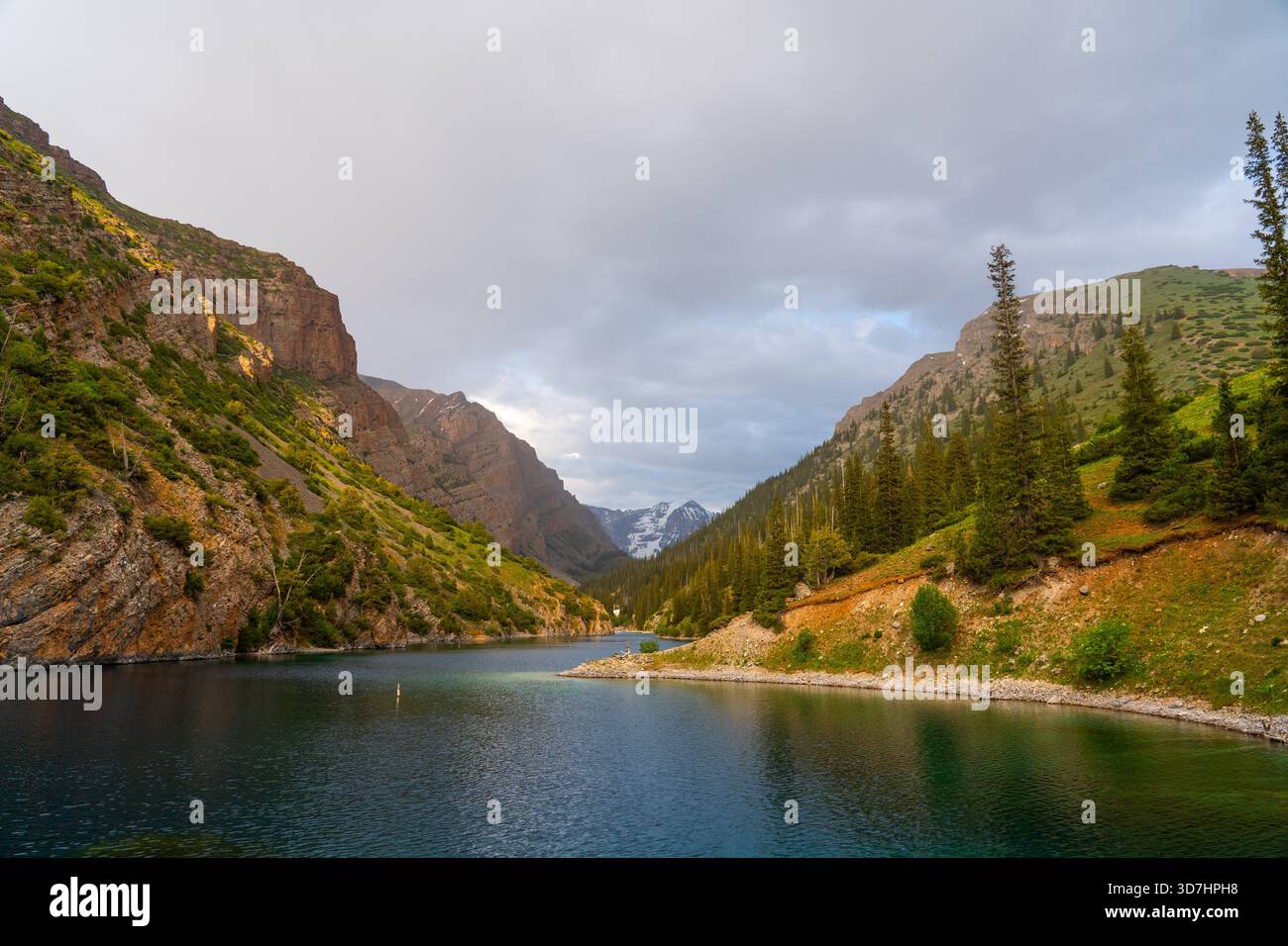 Wide view of a dark blue alpine lake situated at the mouth of a ...