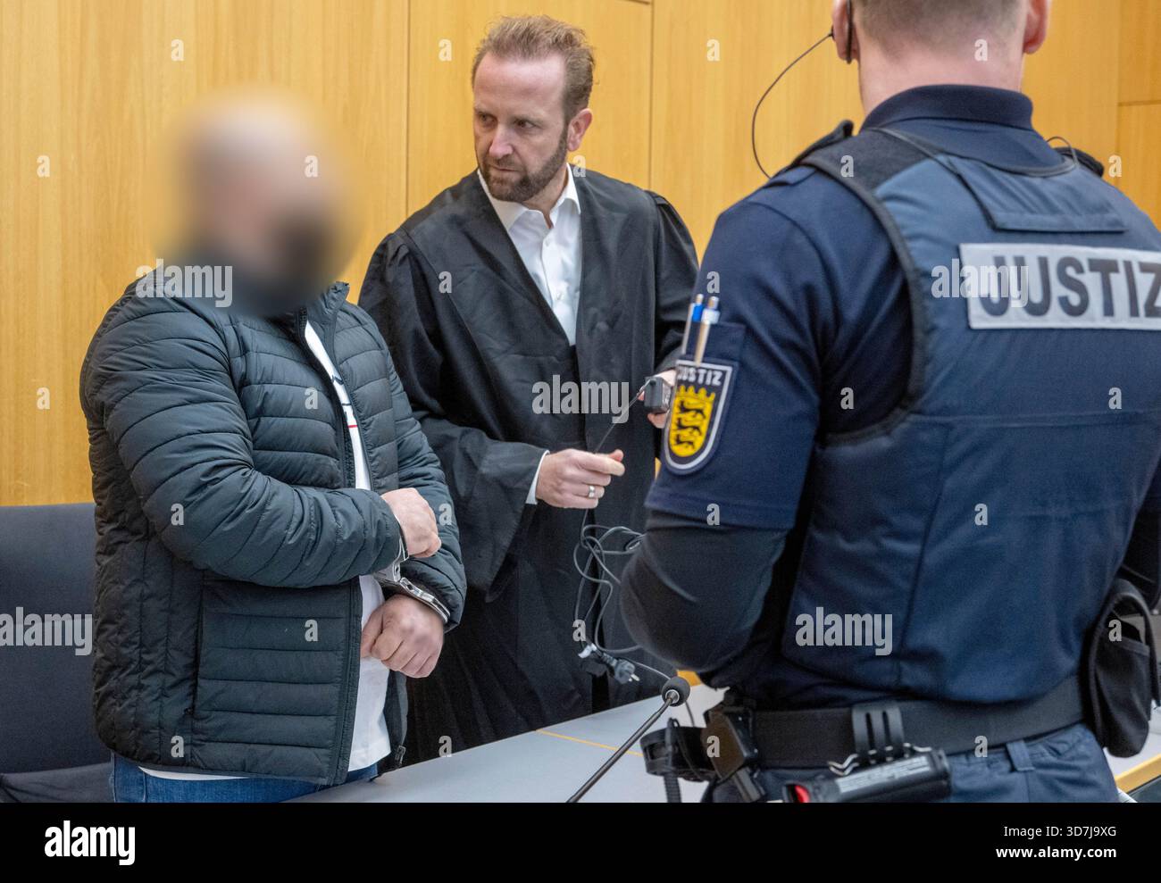 26 November 2025, Baden-Württemberg, Ulm: Judicial officers lead a man ...