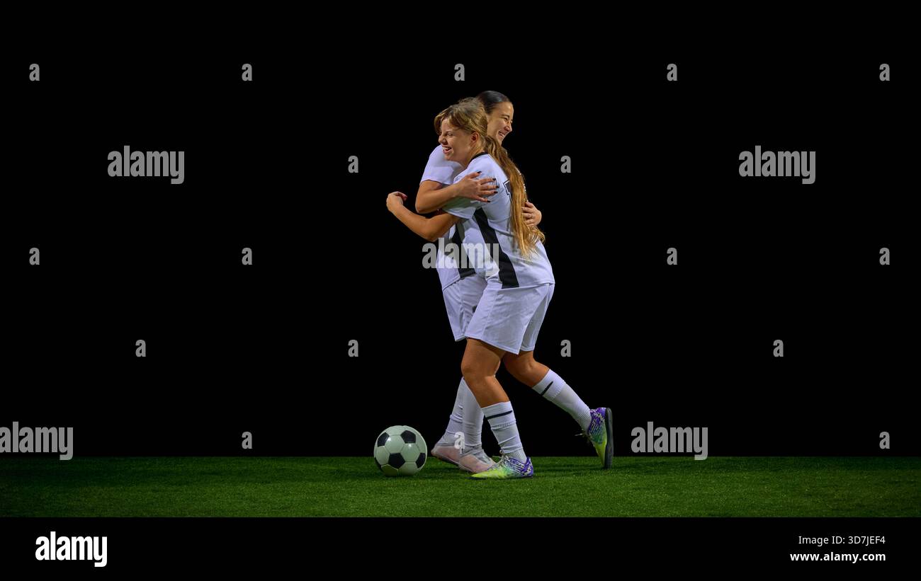 Teenage female soccer teammates hugging in positive moment after play ...