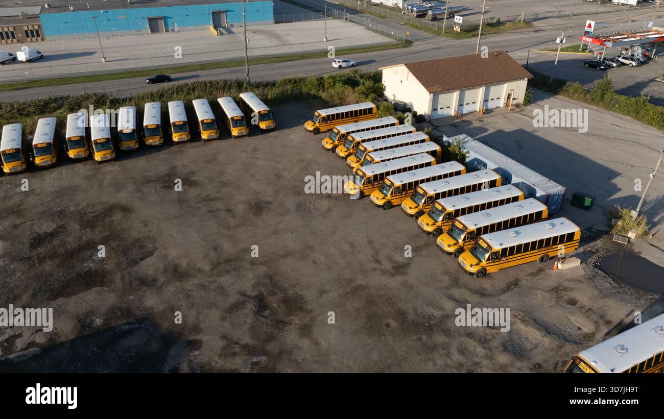 A lot of buses crowded in a depot, with drivers busy loading passengers ...