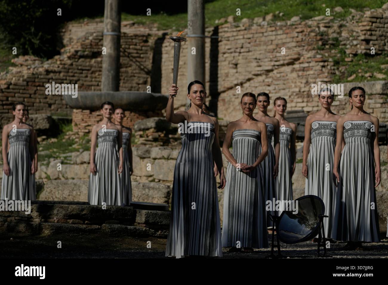 Actress Mary Mina, right, playing the high priestess holds a torch wit ...