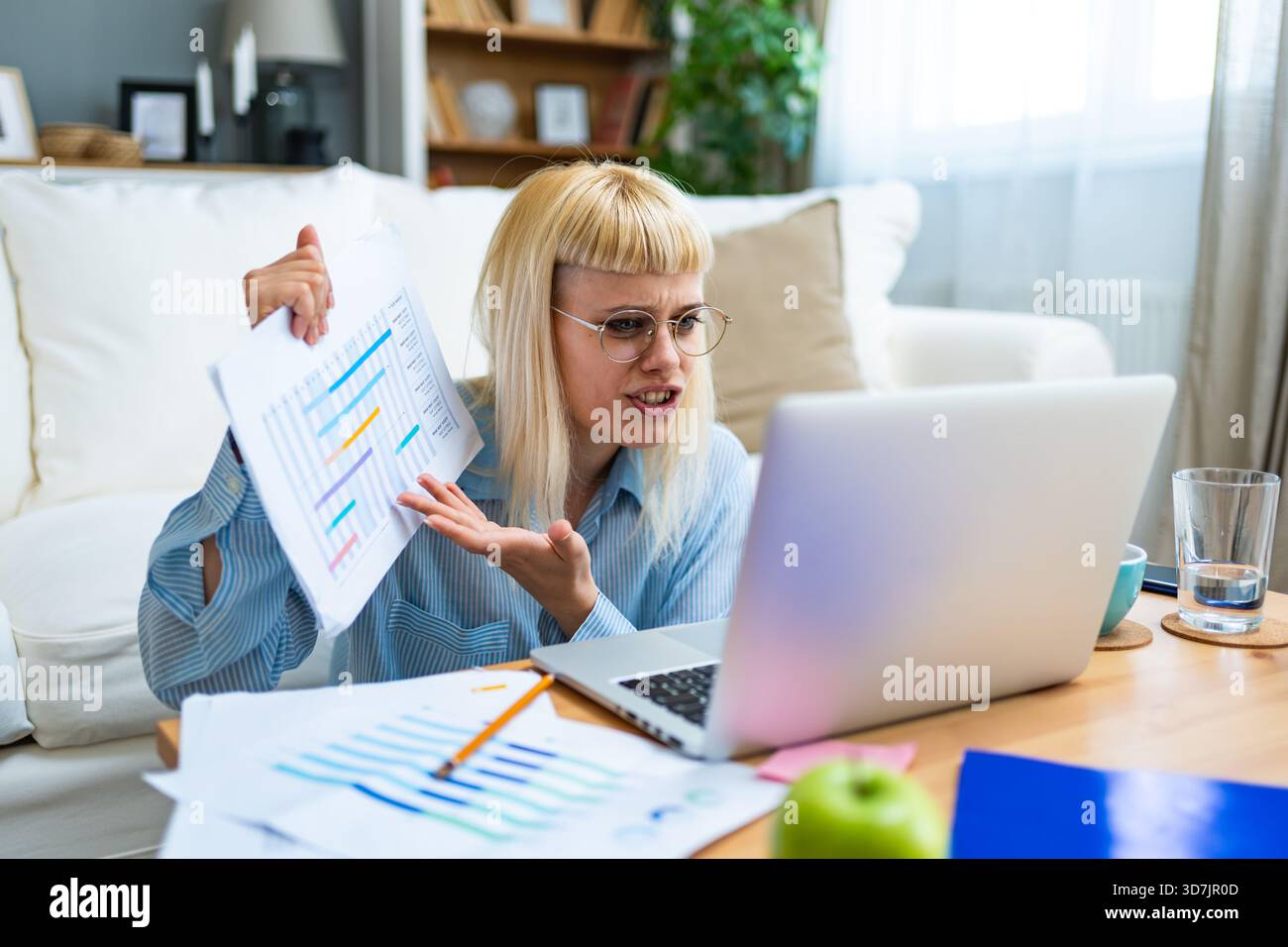 Young professional woman on video call from home holds printed chart ...