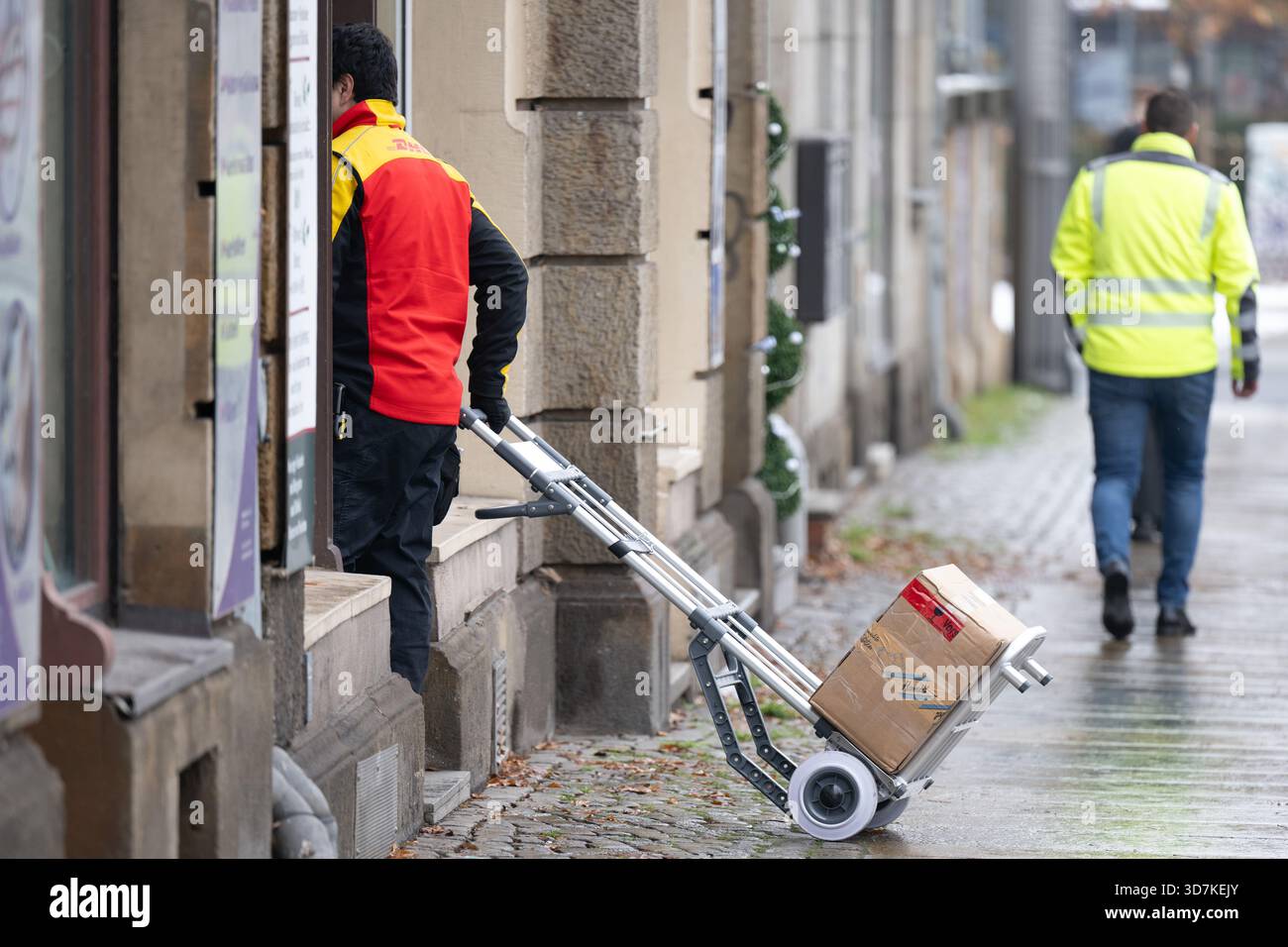 26 November 2025, Saxony, Dresden: A parcel delivery driver from the ...