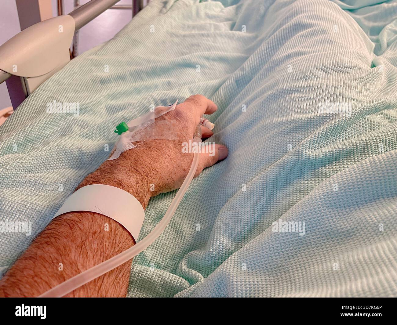 Senior male patient with intravenous cannula inserted into left hand in ...