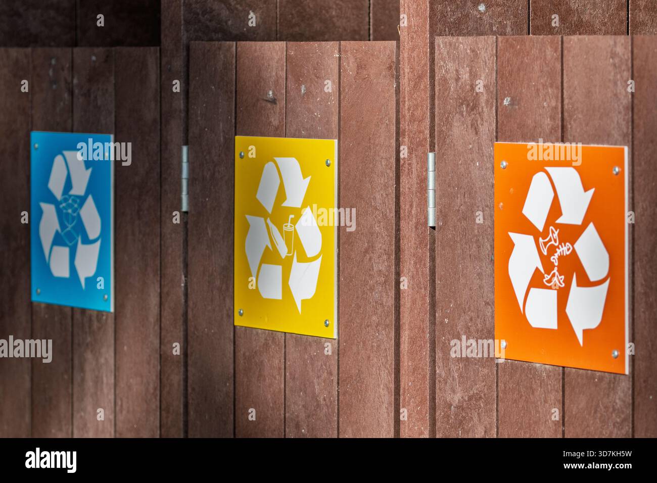 Recycling signs on wooden waste collection bins indicating different ...