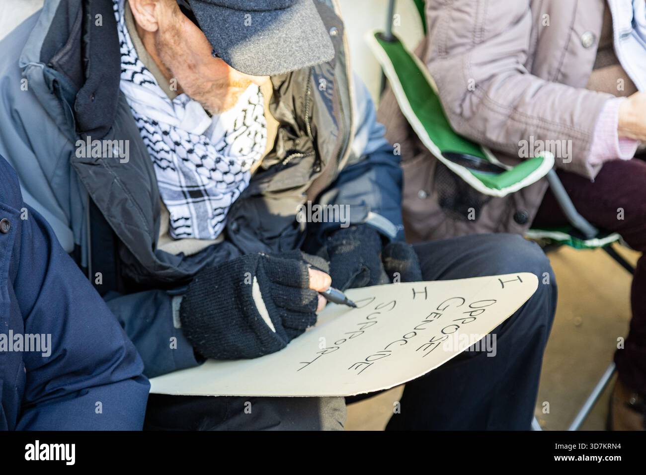 Person writing on placard ahead of the Defend Our Juries protest on the ...