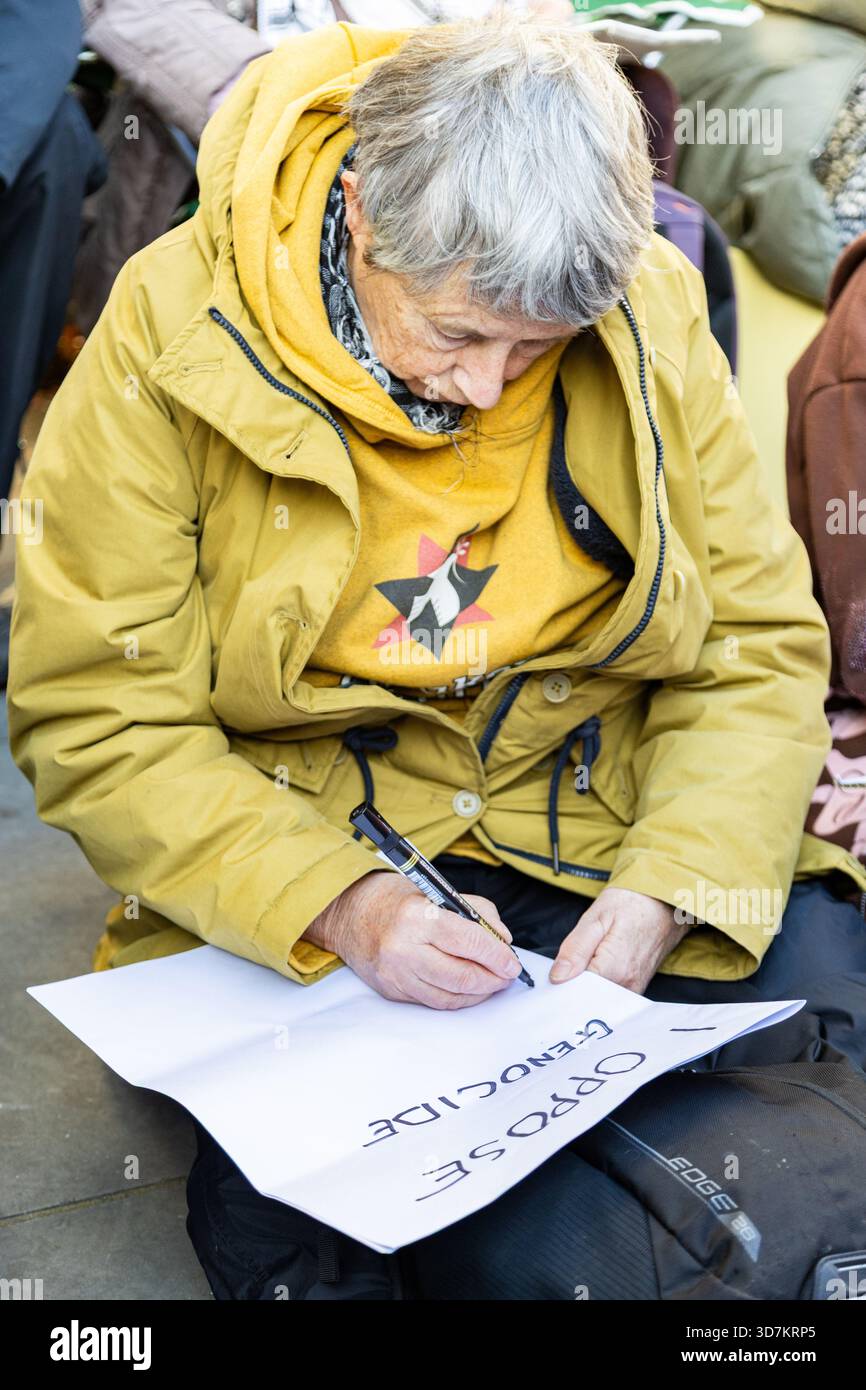Person writing on placard ahead of the Defend Our Juries protest on the ...