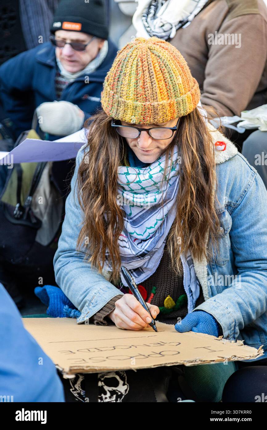 Person writing on placard ahead of the Defend Our Juries protest on the ...