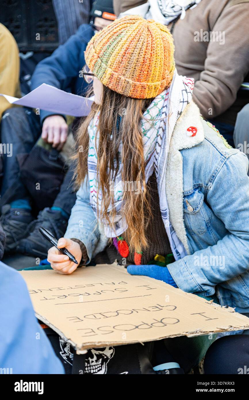 Person writing on placard ahead of the Defend Our Juries protest on the ...