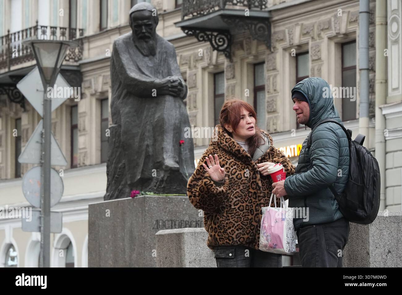 People talk next to a sculpture of the Russian writer Fyodor ...