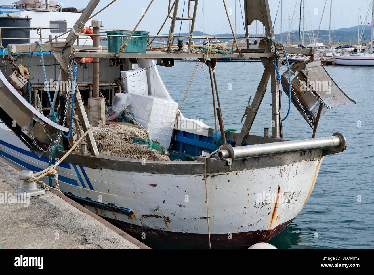 The stern of a large working fishing vessel with metal frames, nets ...