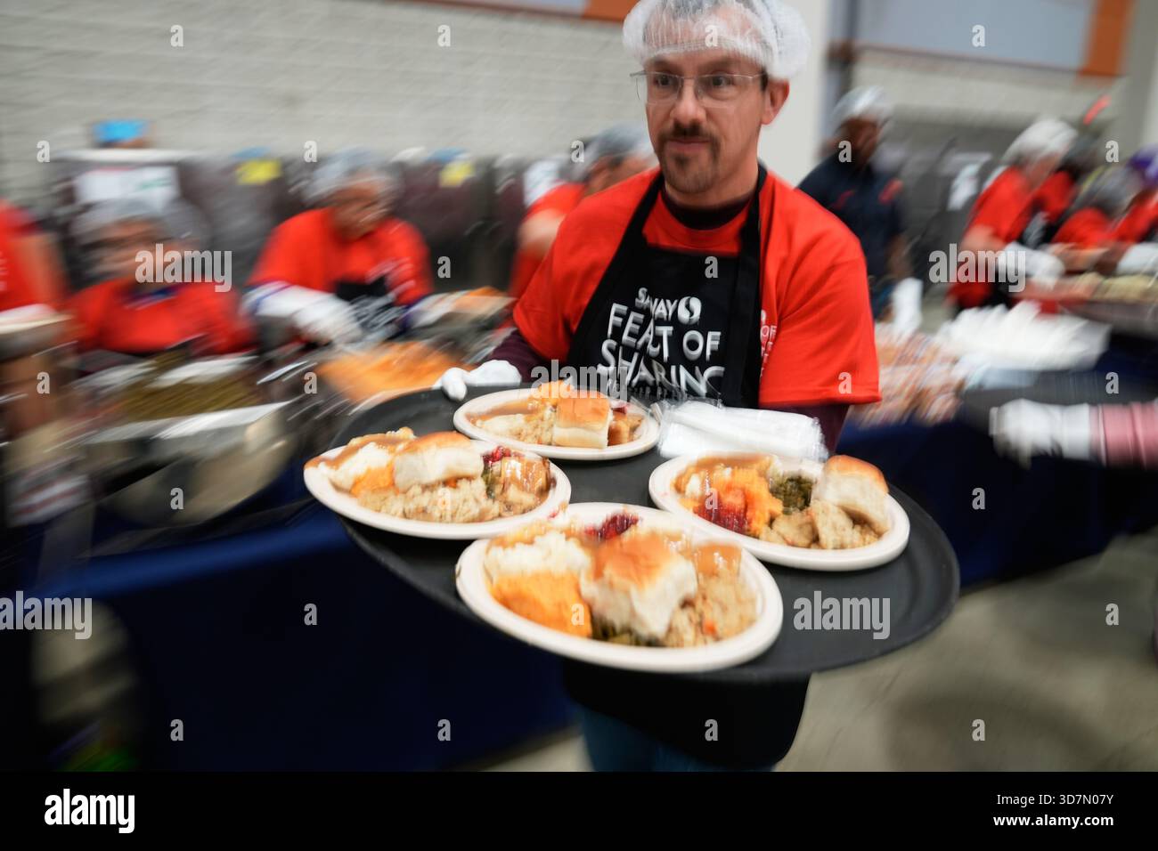 Community members serve meals during the Feast of Sharing, Wednesday ...
