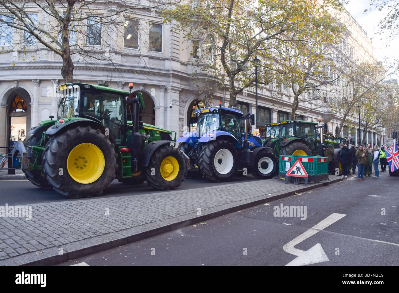 London, UK. 26th November 2025. Tractors block a street next to ...
