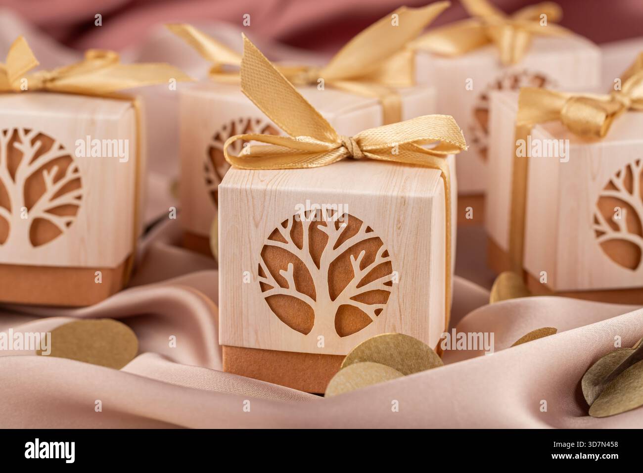 Many beige and brown gift boxes with golden ribbons on the beige silk ...