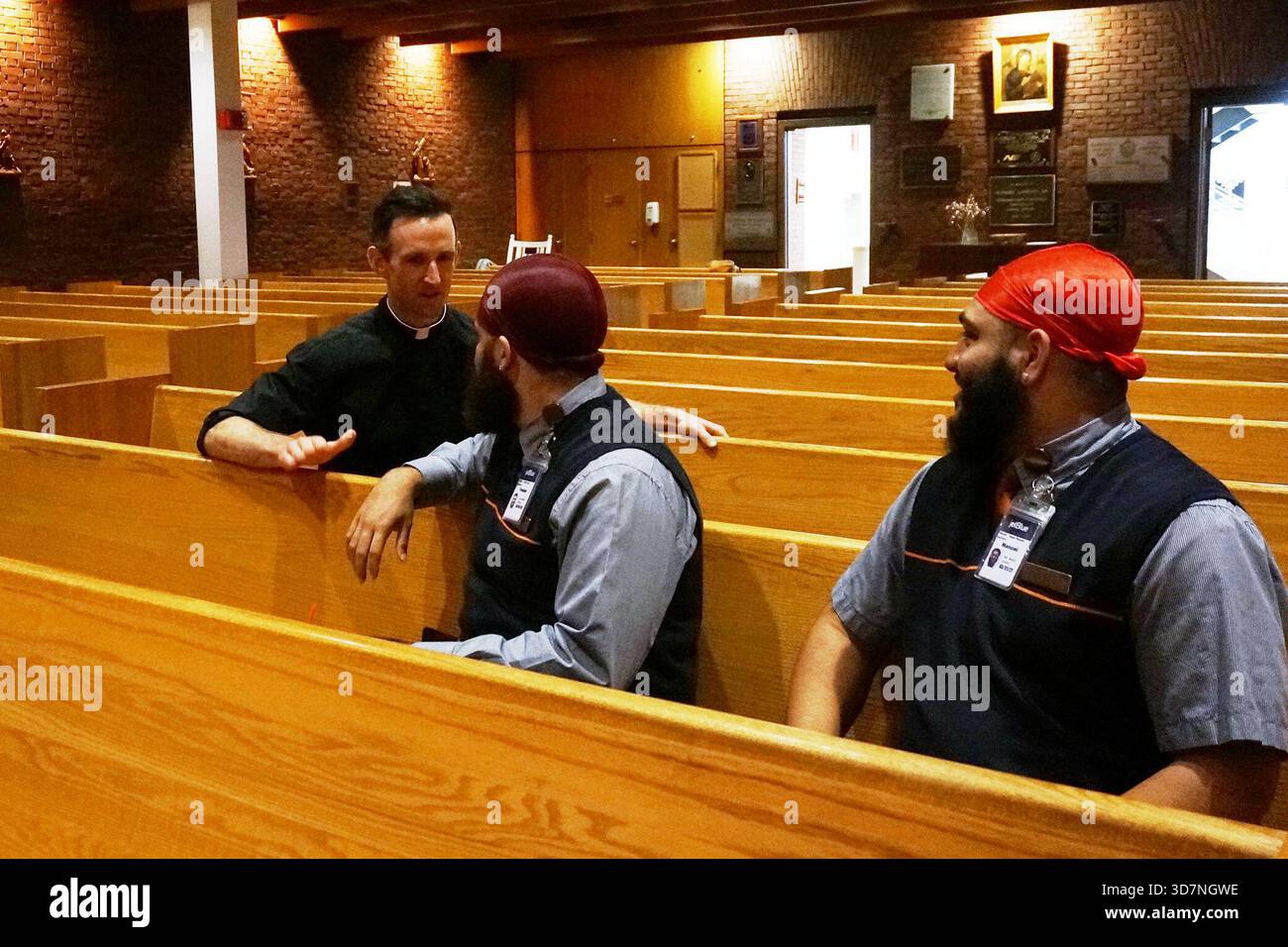 The Rev. Brian Daley speaks with two airline employees after they ...
