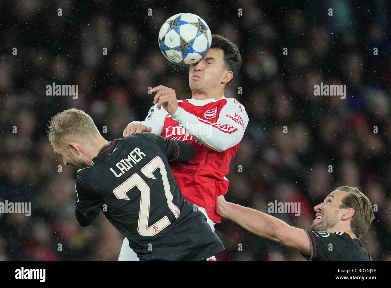 Arsenal's Martin Zubimendi, center, is challenged by Bayern's Konrad ...