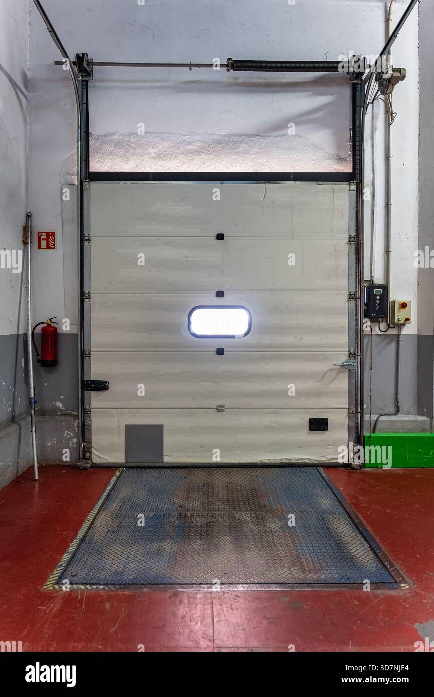 Overhead warehouse door for unloading trucks on a dock platform Stock ...