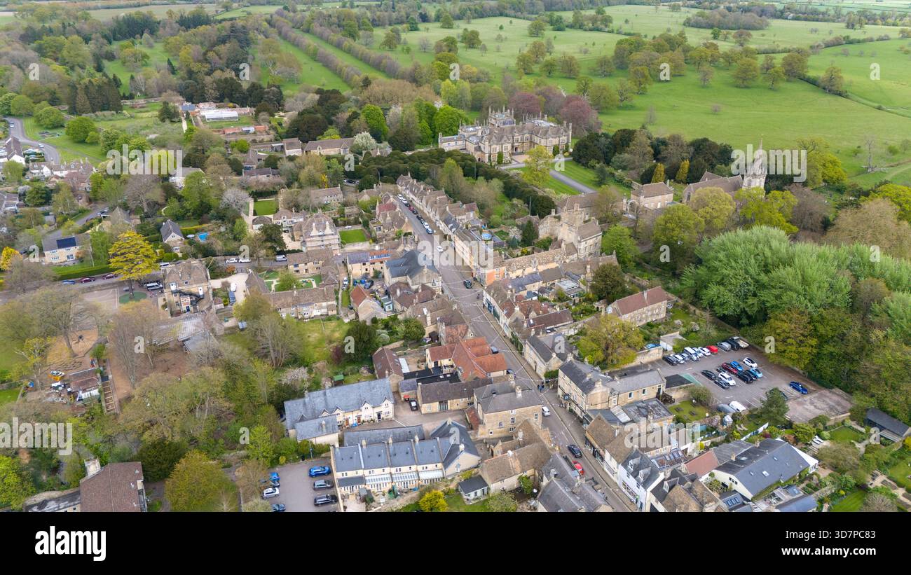 Aerial view of honey-stone buildings nestled amidst lush greenery and ...