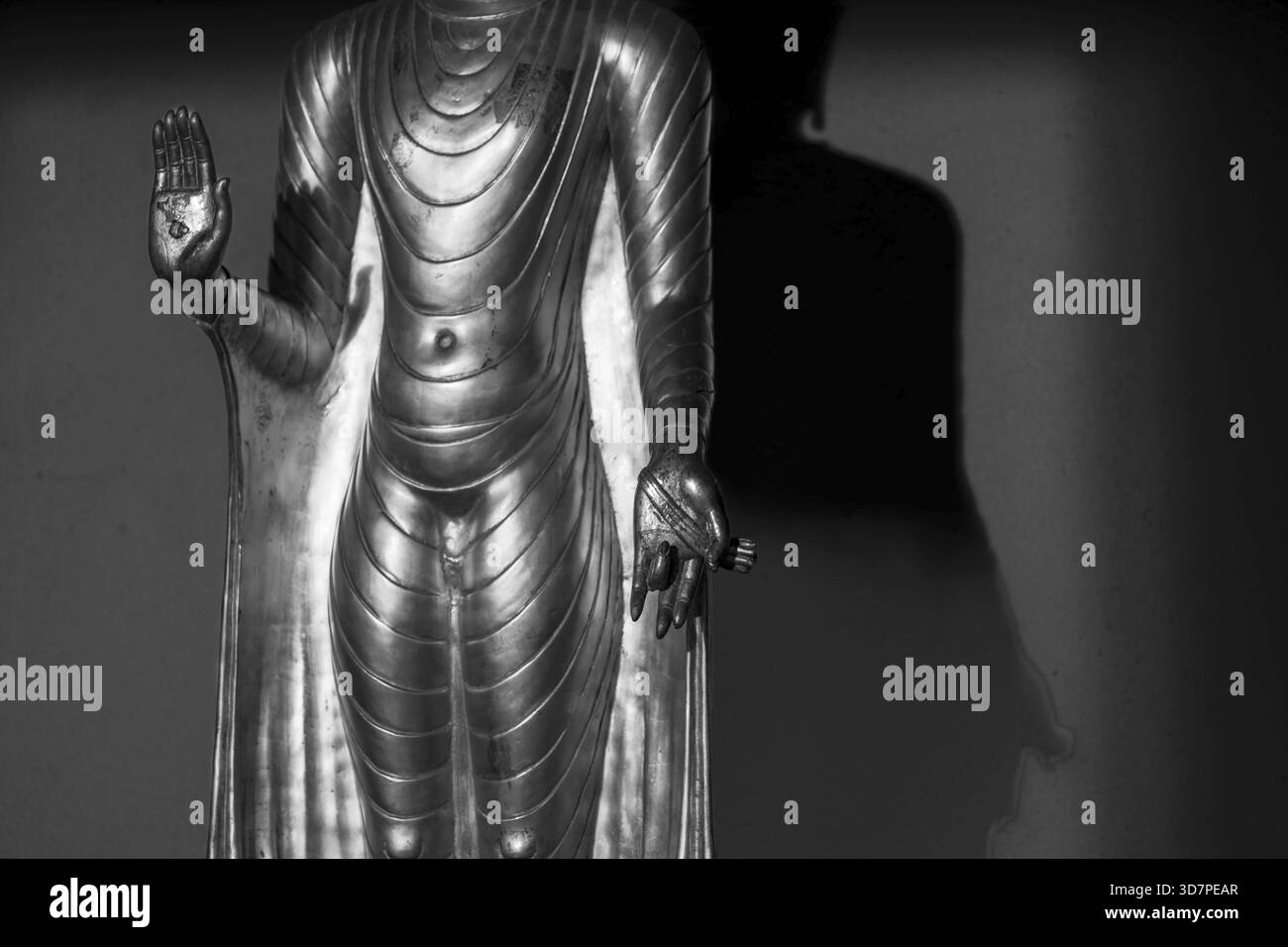 Standing gilded Buddha statue, right hand (raised, open palm outwards ...