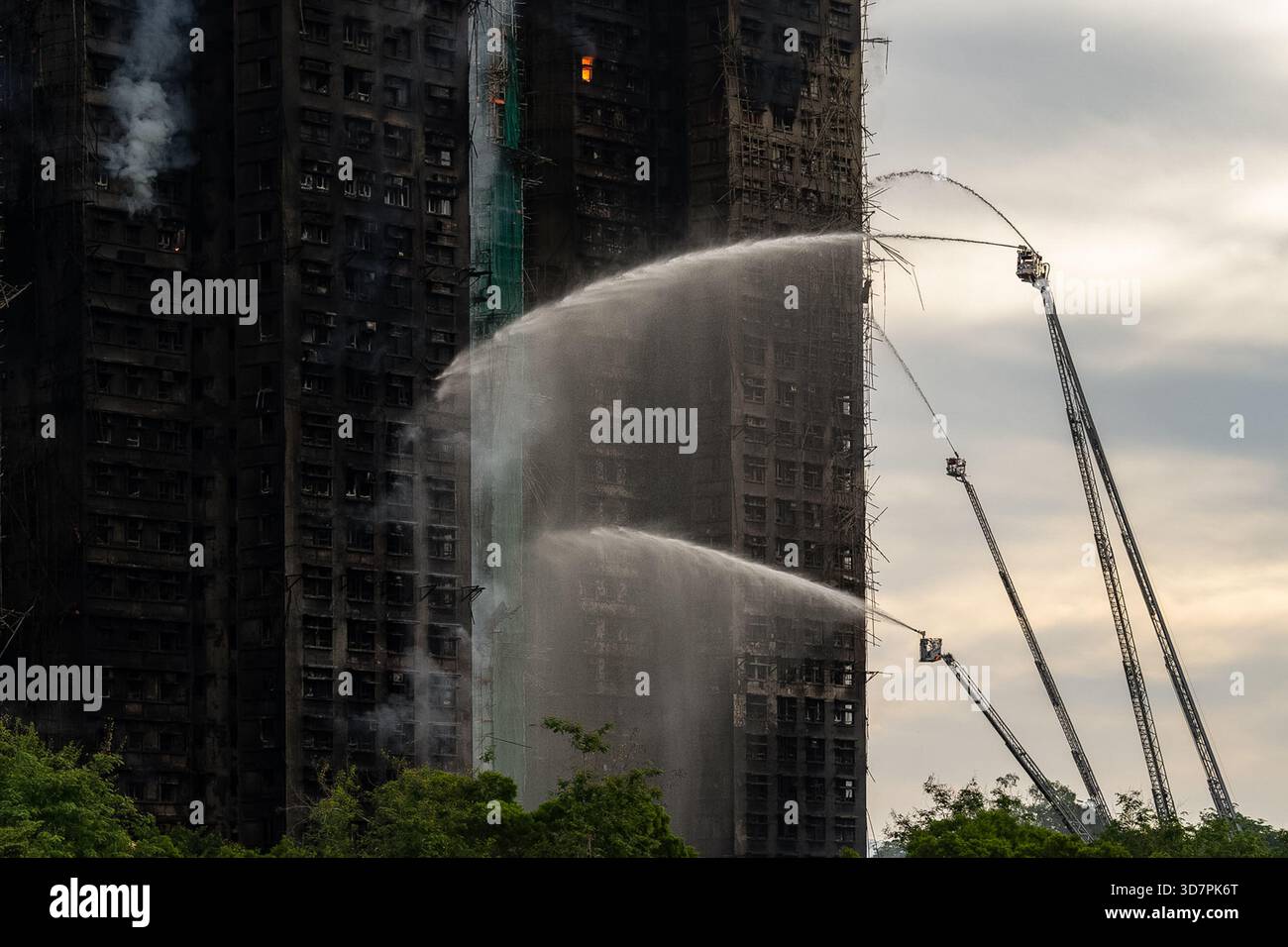 Firefighters work to extinguish a fire that broke out at Wang Fuk Court ...