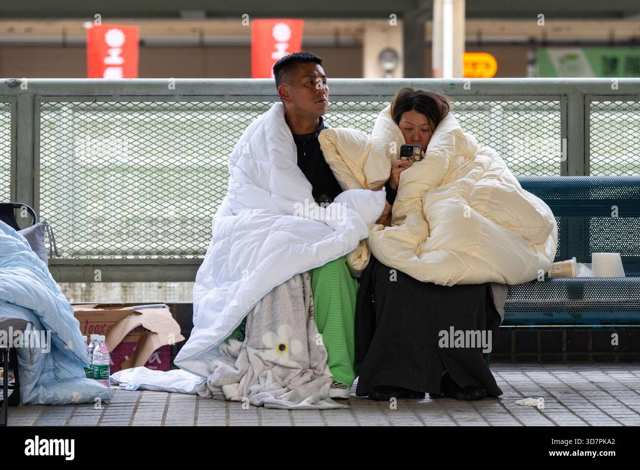 Residents rest at the fire scene at Wang Fuk Court, a residential ...