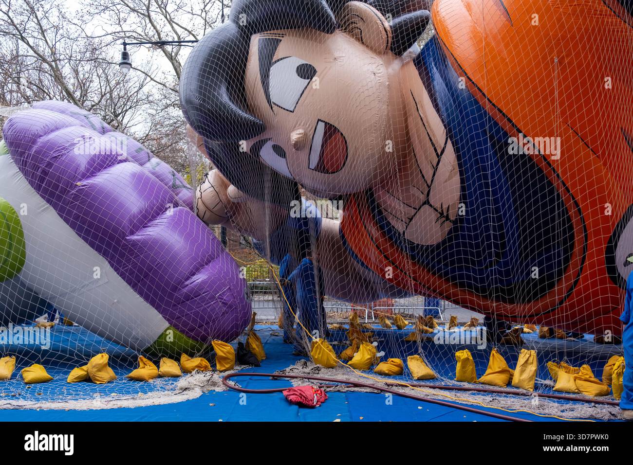 A Dragonball Z balloon seen under netting as tech crews work on ...