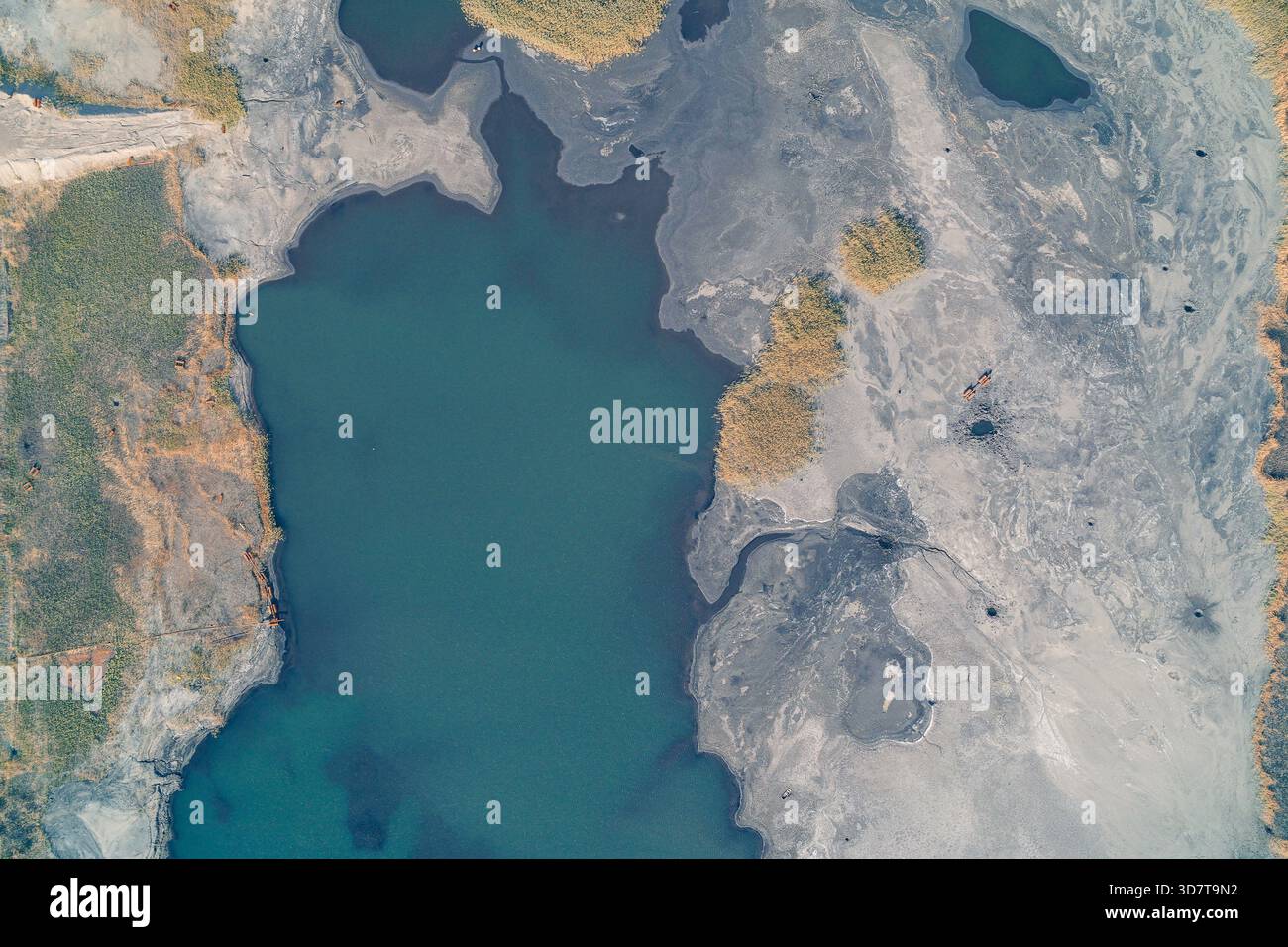 Aerial abstract of a mining tailings pond. The deep turquoise water ...