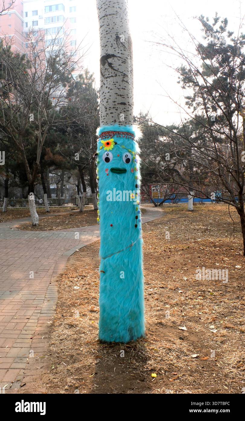 Trees are put on brightly colored "sweaters" for winter at a park in ...