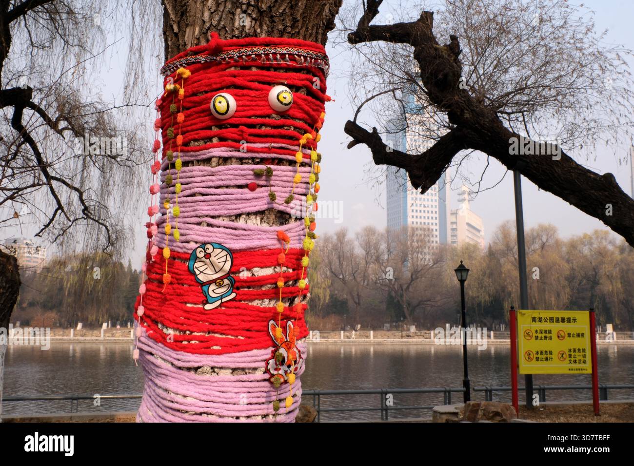 Trees are put on brightly colored "sweaters" for winter at a park in ...