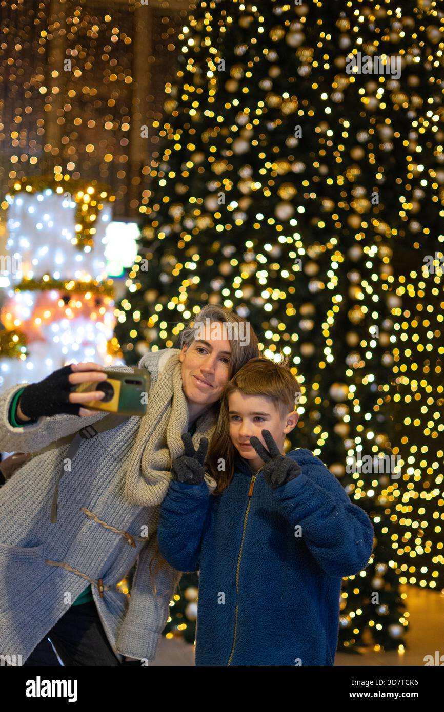 Mother and son making peace signs while taking a selfie in front of a ...
