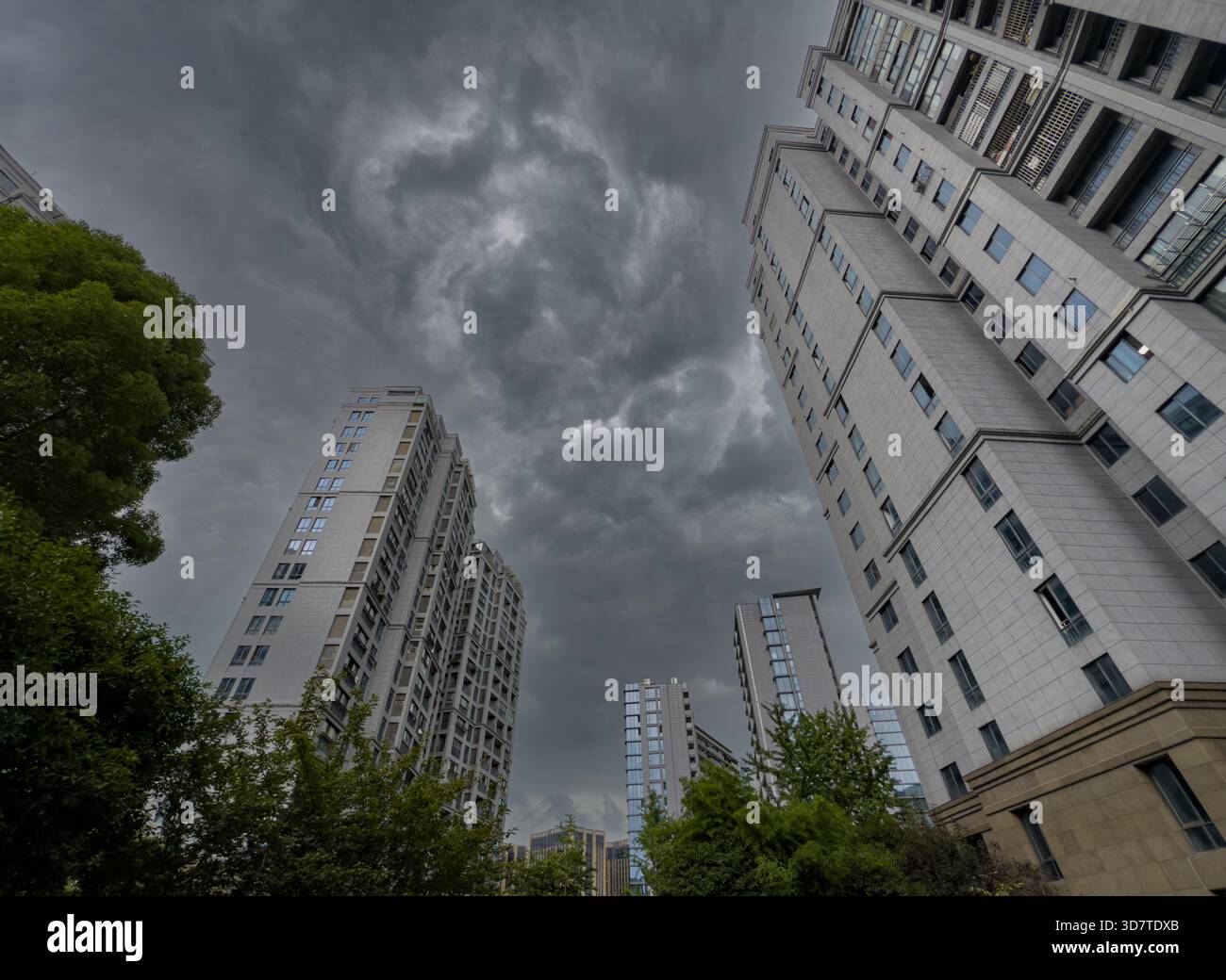 Tall residential buildings under a dramatic cloudy sky during daytime ...