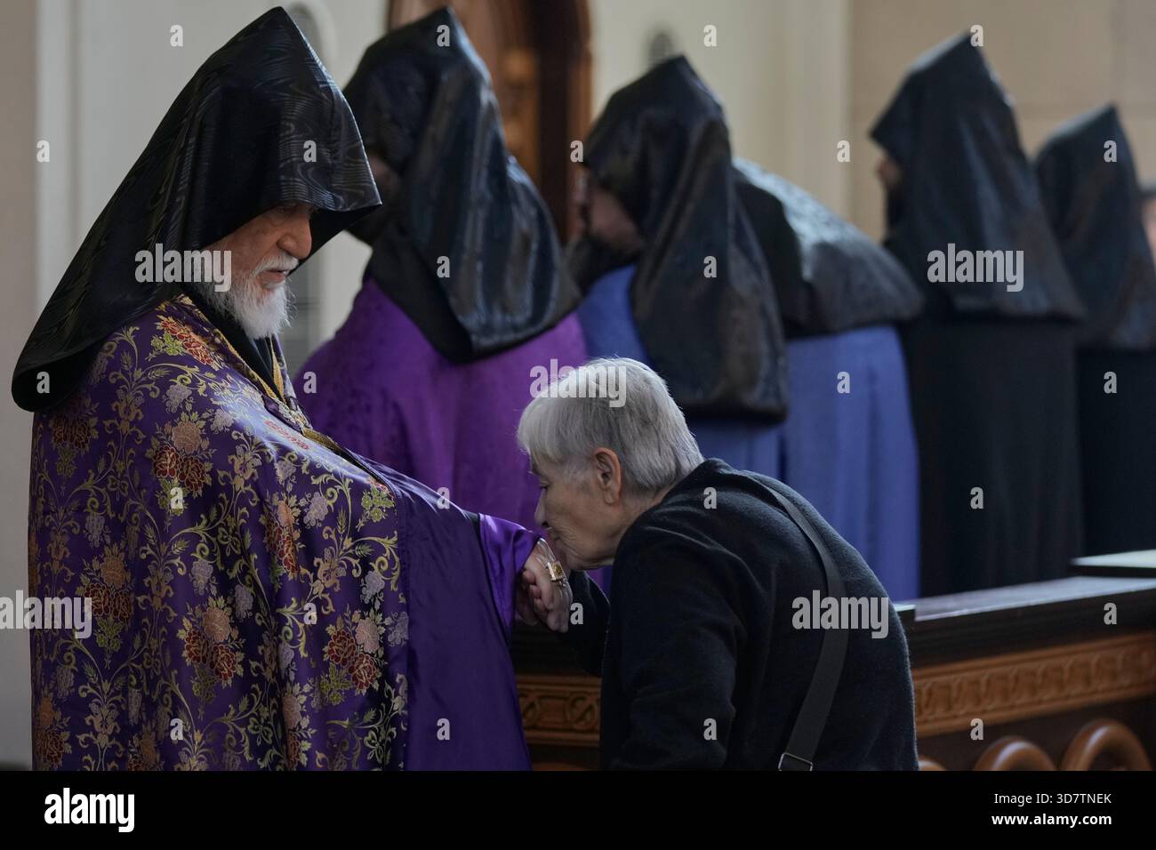 A woman kisses a hand of Armenian patriarch Aram Kashashian at the ...