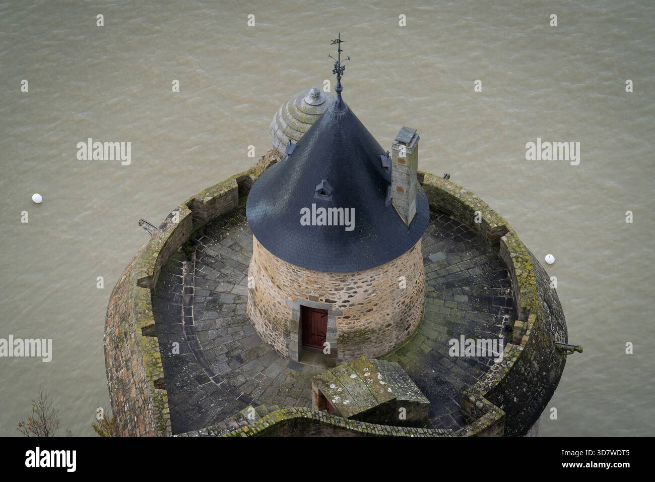 Medieval stone tower of Mont Saint-Michel rising above the tidal waters ...