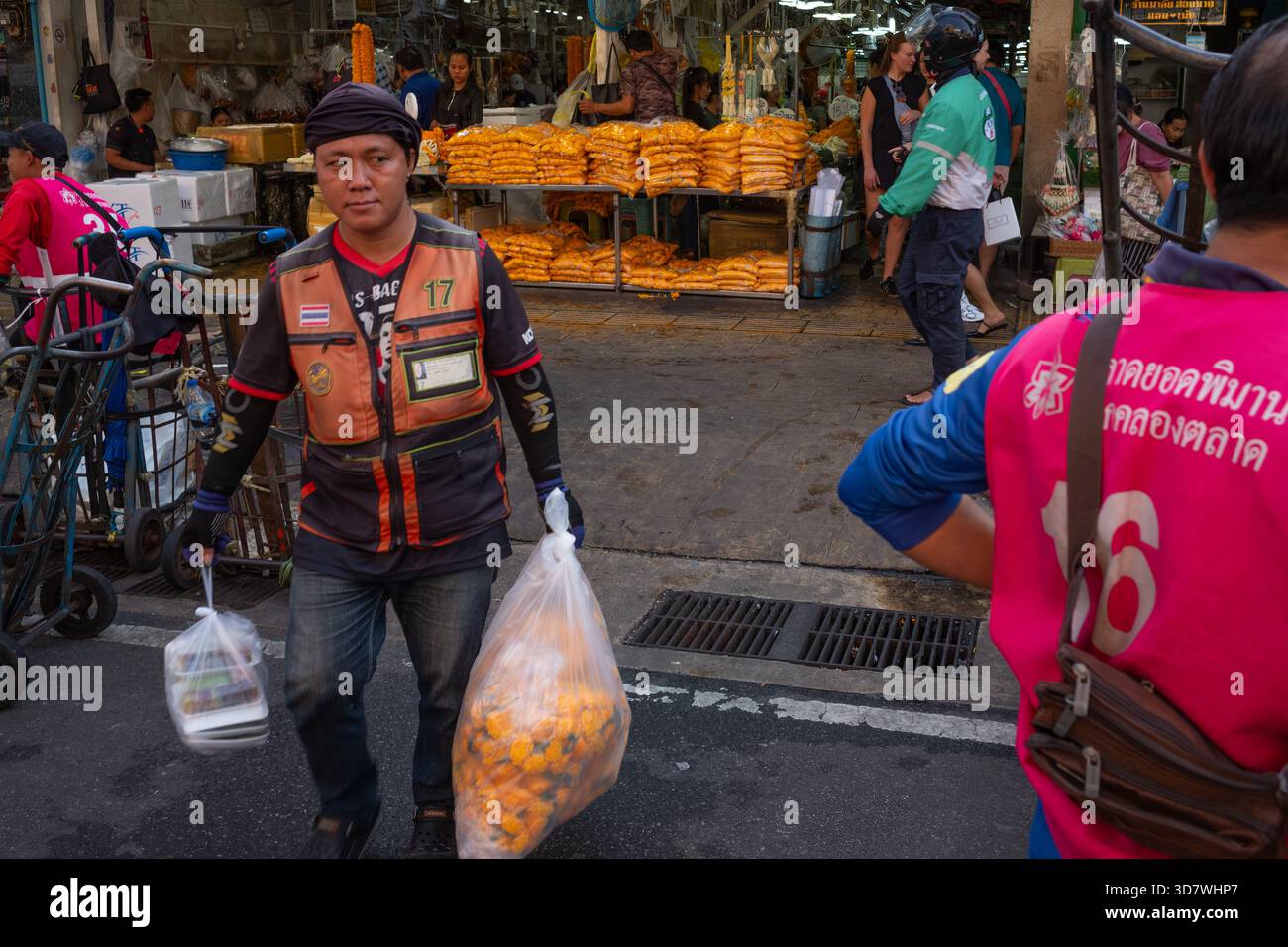 A delivery man grabs a bag of chrysanthemums, passing the entrance of ...