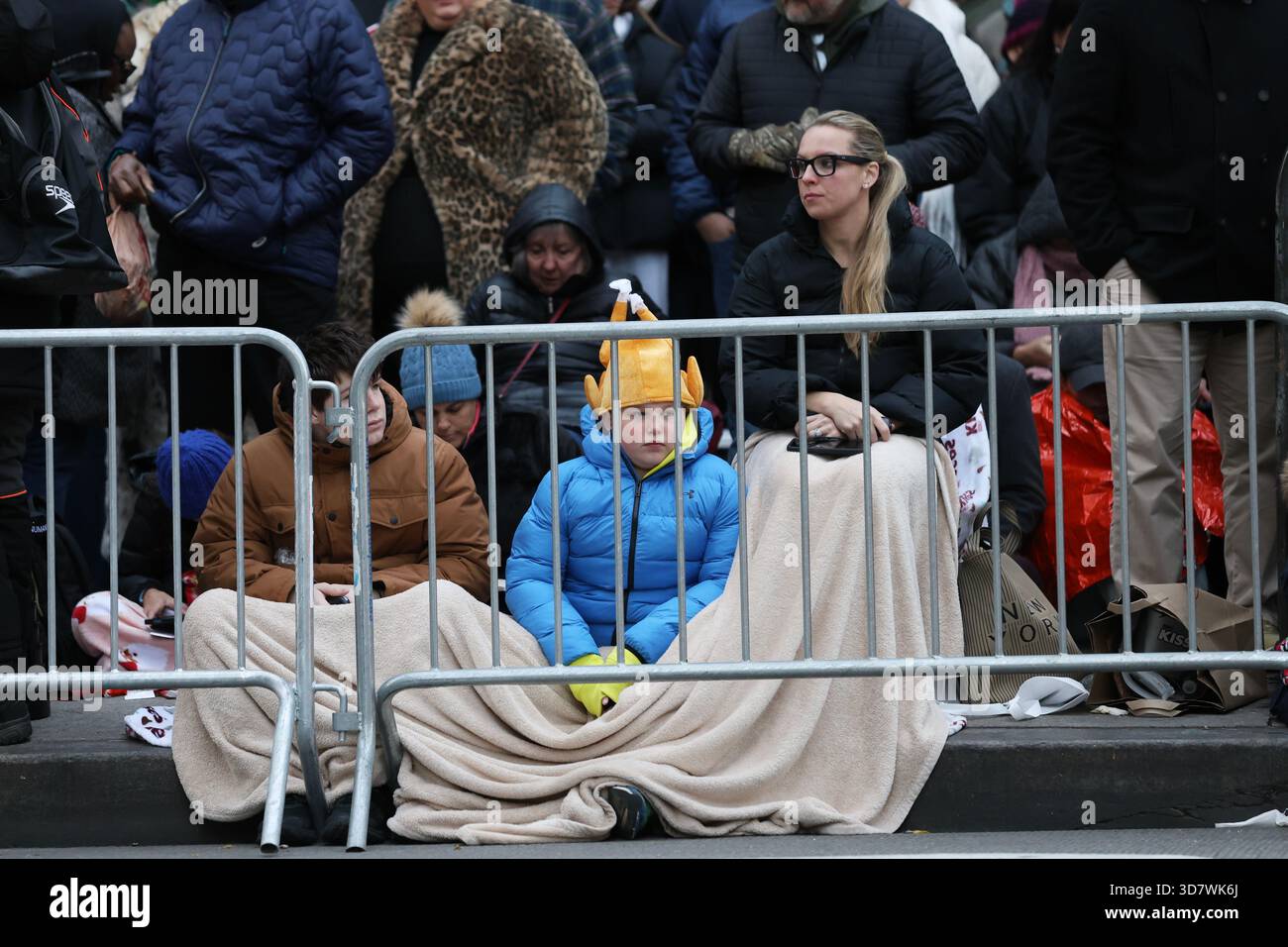 People wait along Sixth Avenue for the start of the Macy's Thanksgiving Day Parade, Thursday ...