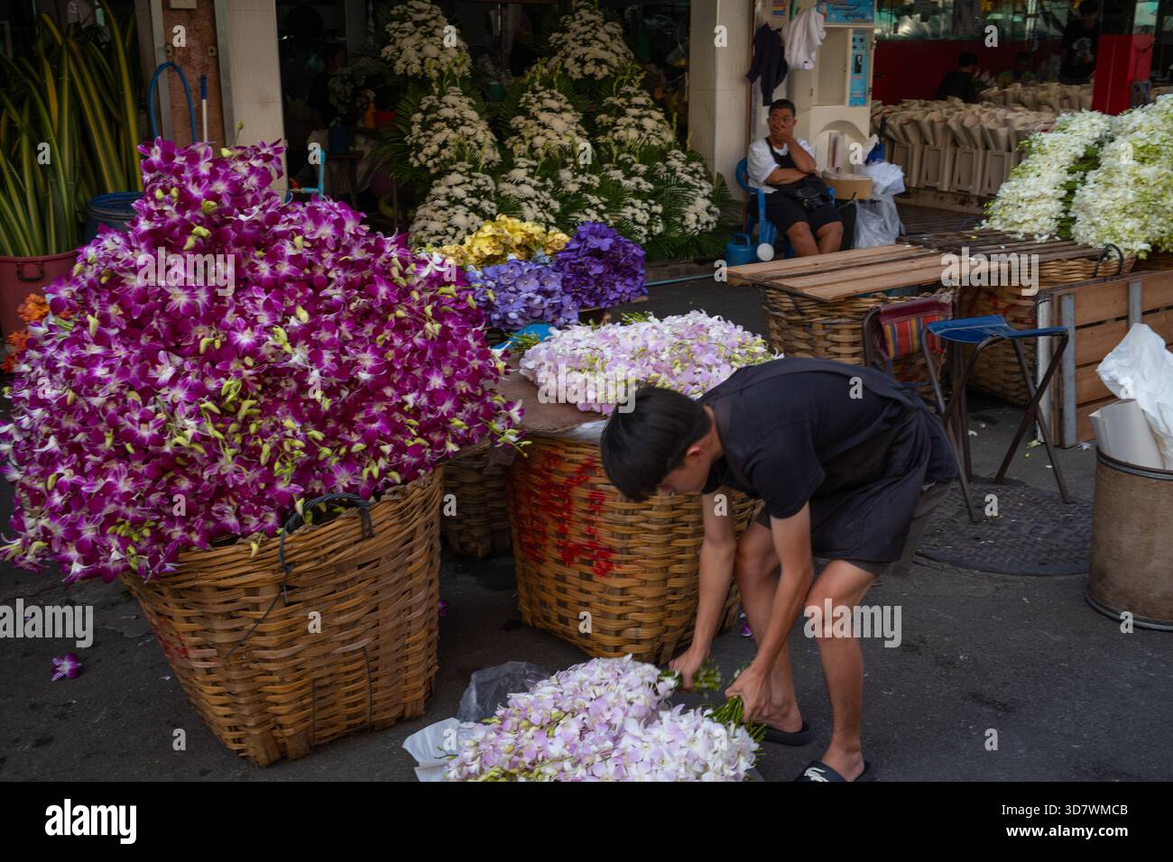 A man stocks flowers at a booth in the flower market in Bangkok. (Photo ...