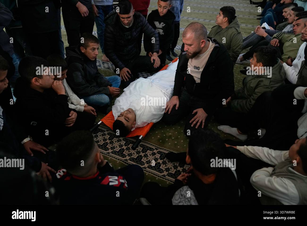 Mourners take the last look at the body of Palestinian Osama Kameel, 20 ...