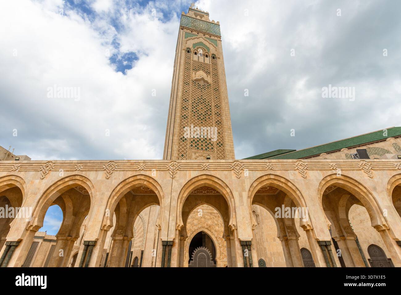 Tall minaret and ornate lower arches with Moroccan mosaic details at ...