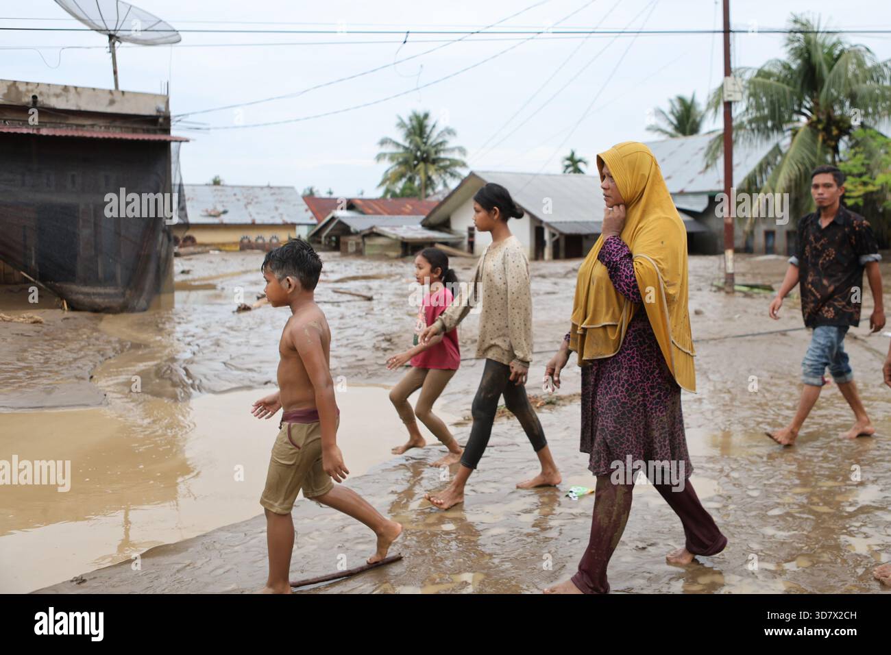 (251127) -- ACEH, Nov. 27, 2025 (Xinhua) -- Villagers walk near a flood ...