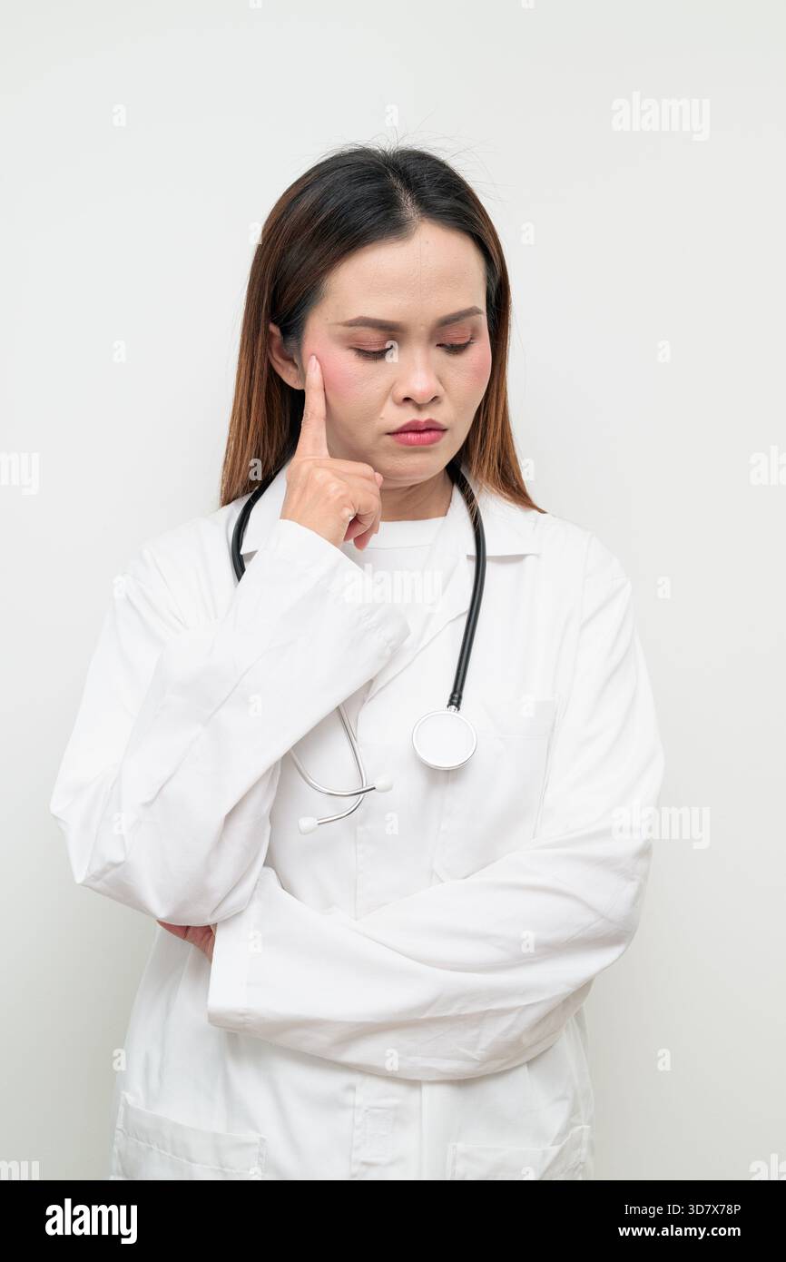 Studio portrait of pensive Asian healthcare professional wearing a ...