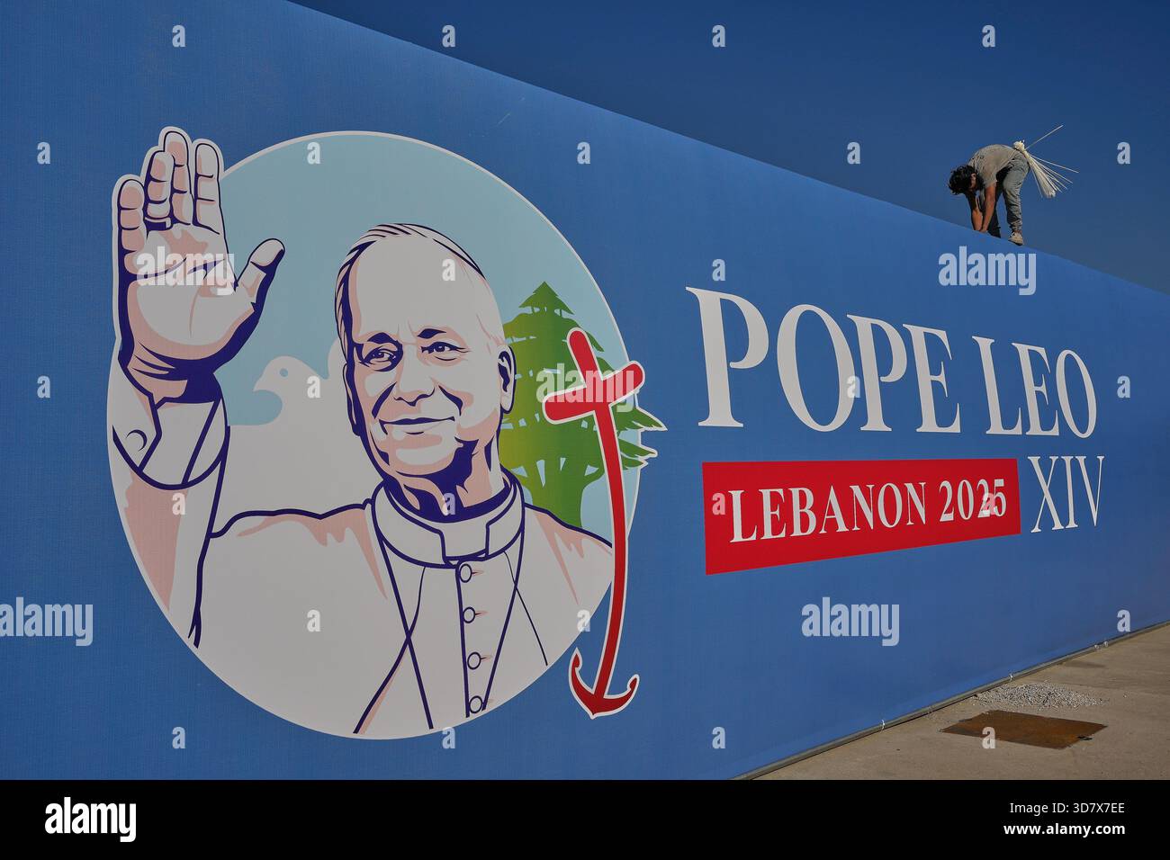 A worker sets a billboard displays an image of Pope Leo XIV in ...