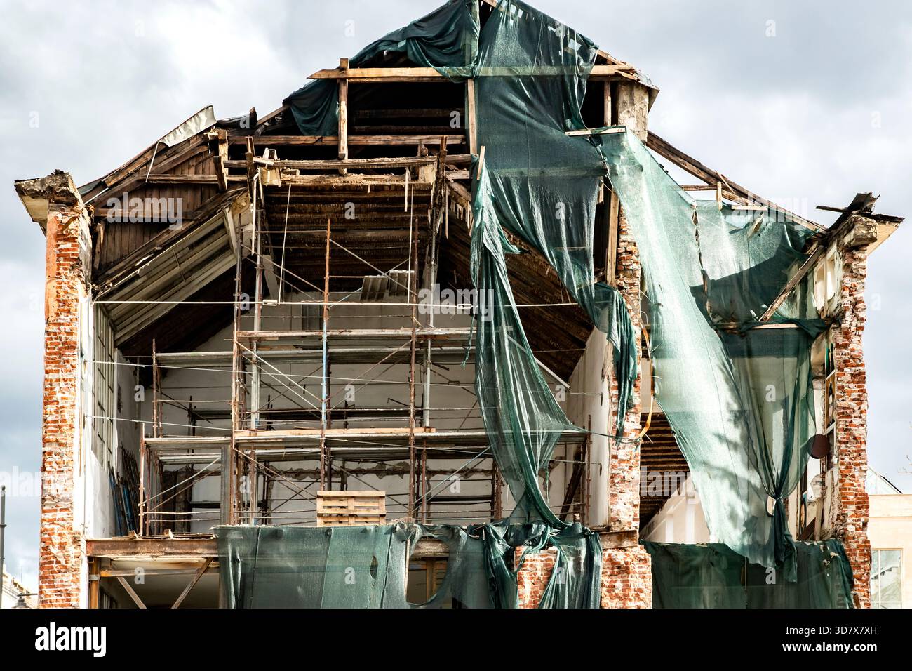 Partially demolished old building with scaffolding and crane ...