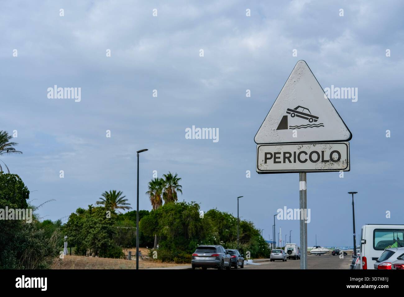 Triangular danger sign with car-falling graphic and “PERICOLO” text ...