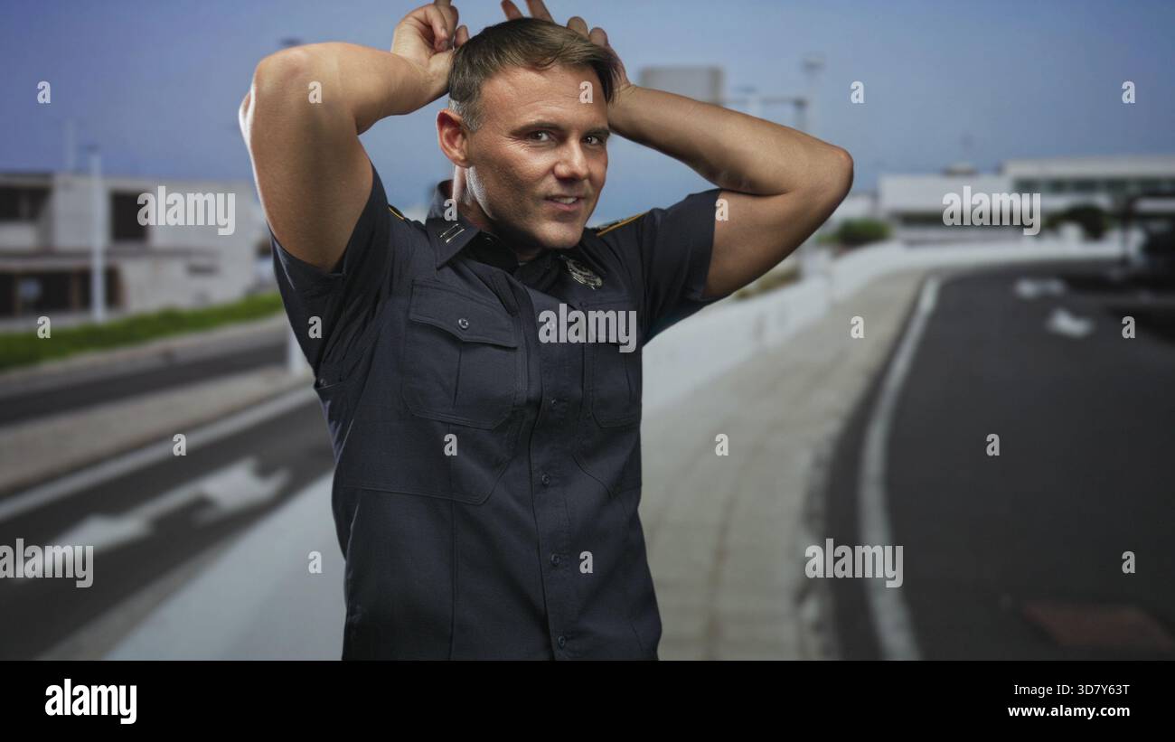 Man police officer in uniform showing arms and hands behind head making ...