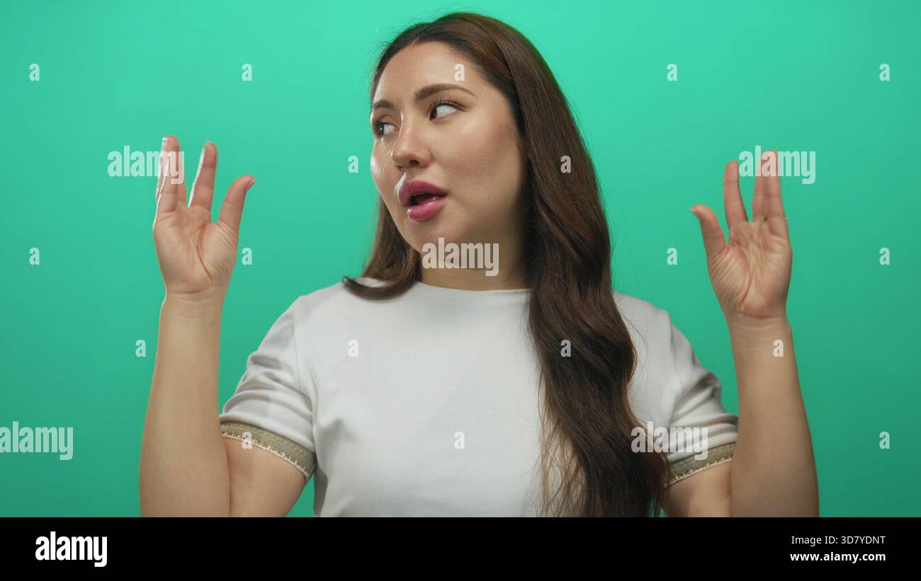 Young hispanic woman makes talking with hands gesture in a studio ...