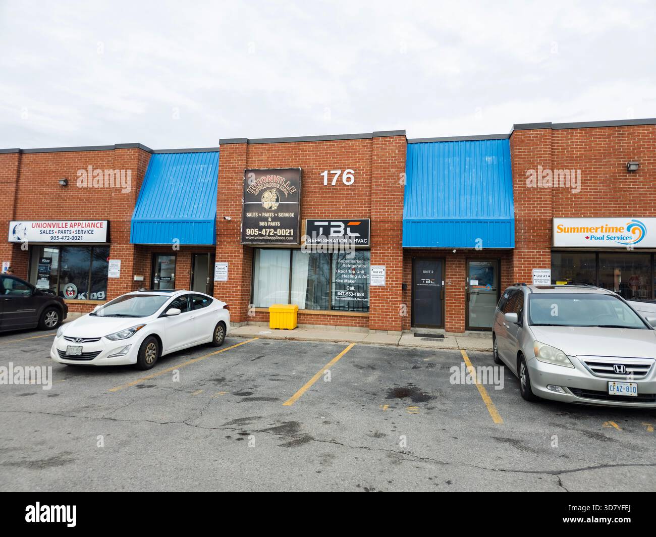 Red brick plaza at 176 Bullock Drive with blue awnings, three ...