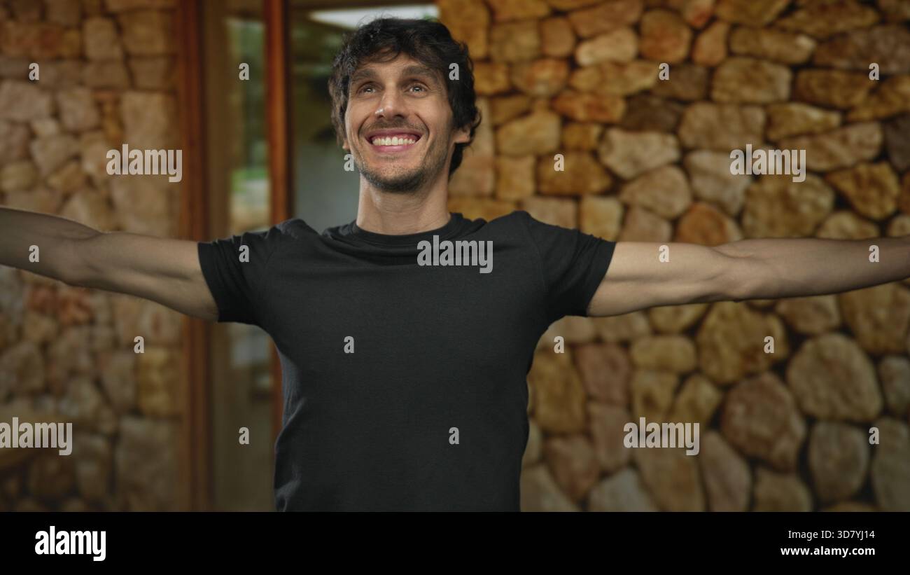 Man with outstretched arms and a bright smile showing open posture in ...