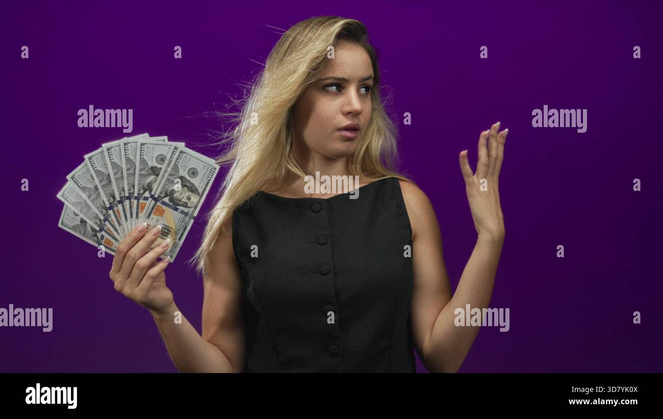 Woman fanning a stack of us dollar bills and shrugging with free hand ...